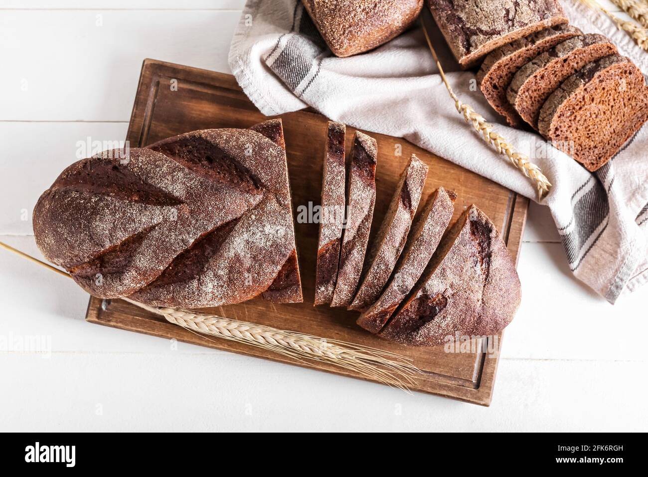 Board with fresh cut bread on light background Stock Photo - Alamy