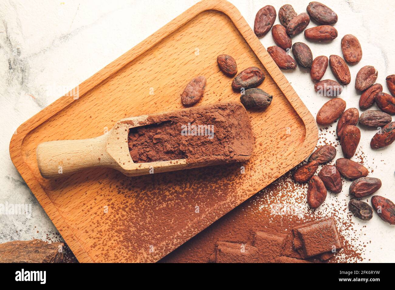 Scoop with cocoa powder and beans on light background Stock Photo - Alamy