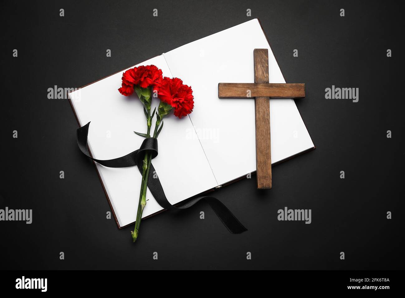 Book with carnation flowers and cross on dark background Stock Photo ...