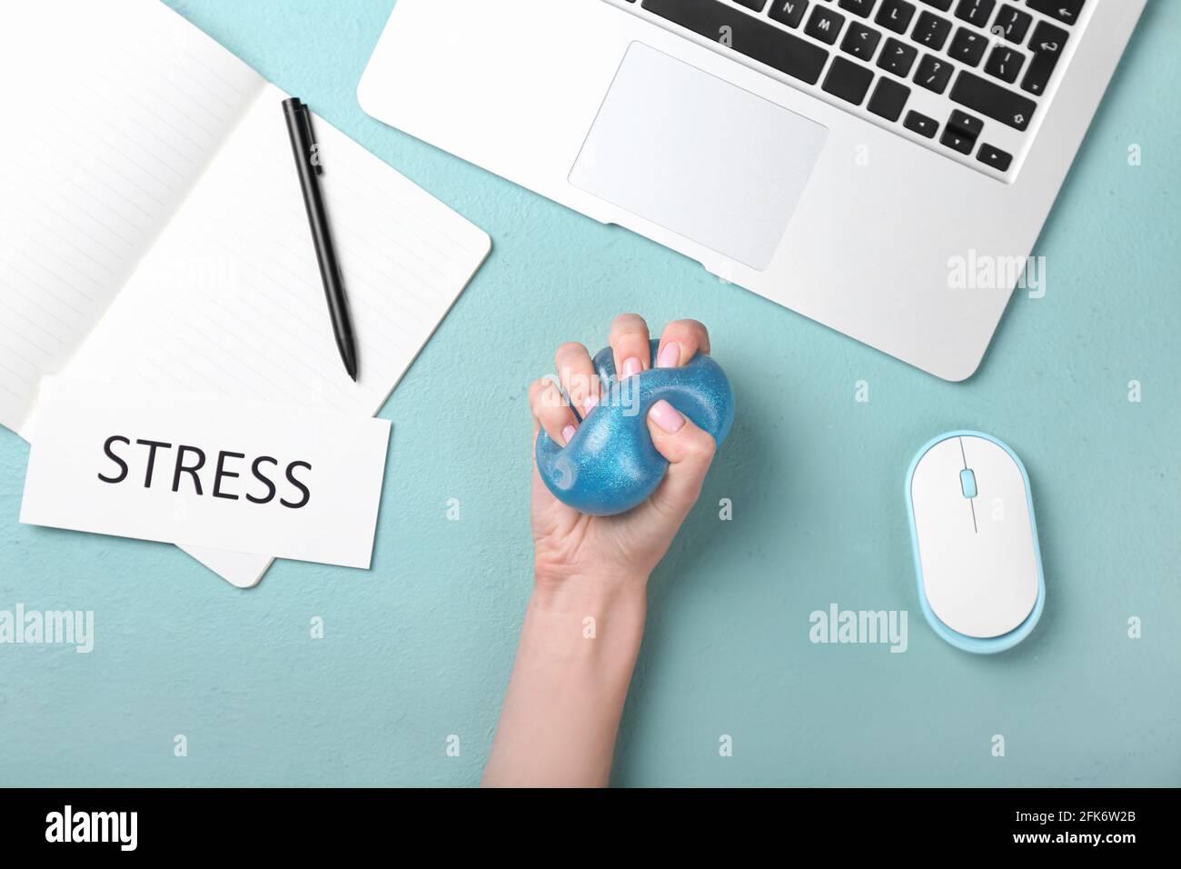 Woman squeezing stress ball while working with laptop in office Stock ...