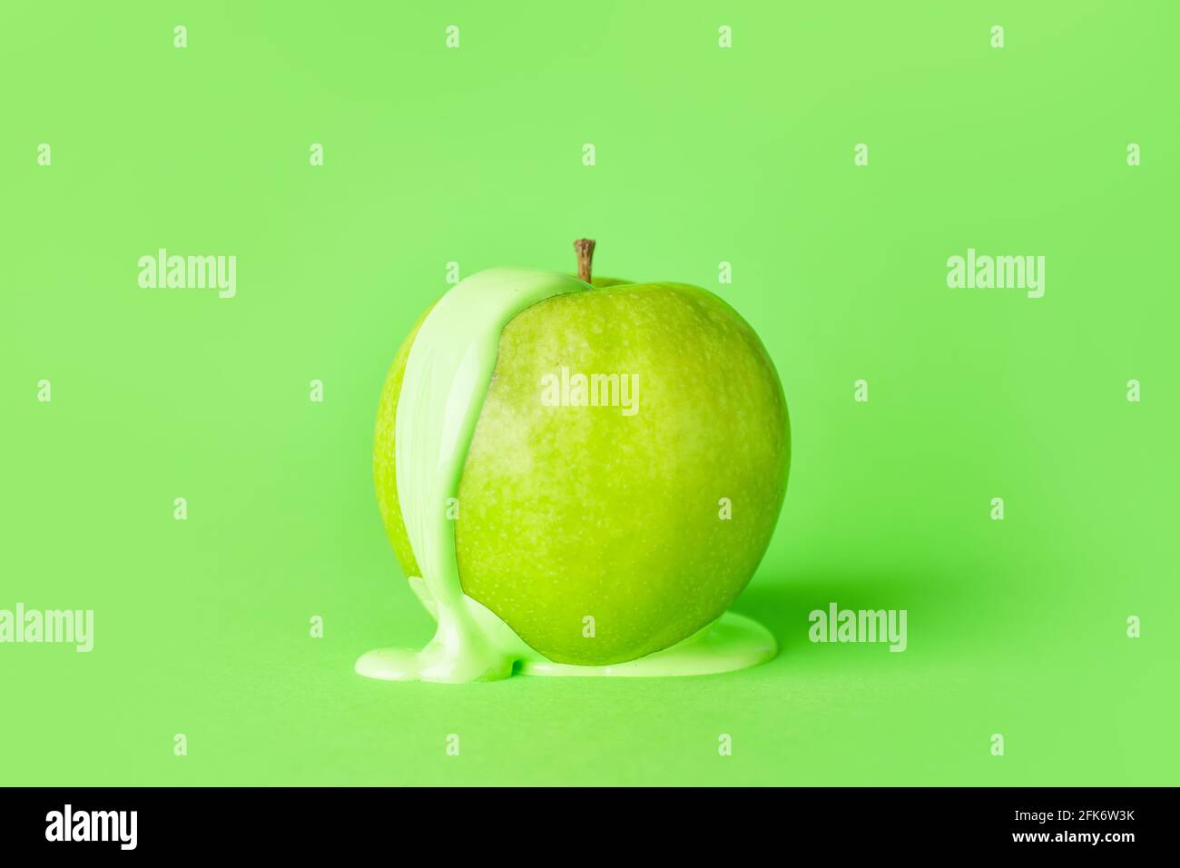 Green apple with white paint on color background Stock Photo - Alamy