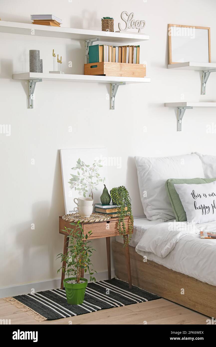 Wooden bedside table with decor in interior of modern room Stock Photo ...
