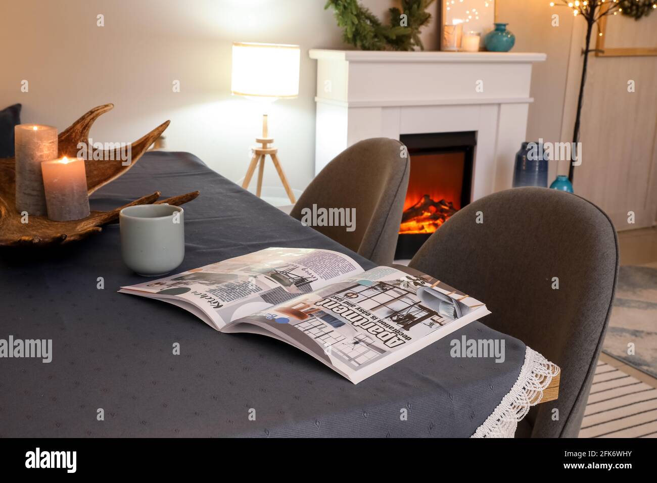 Magazine on table in interior of modern dining room with fireplace ...