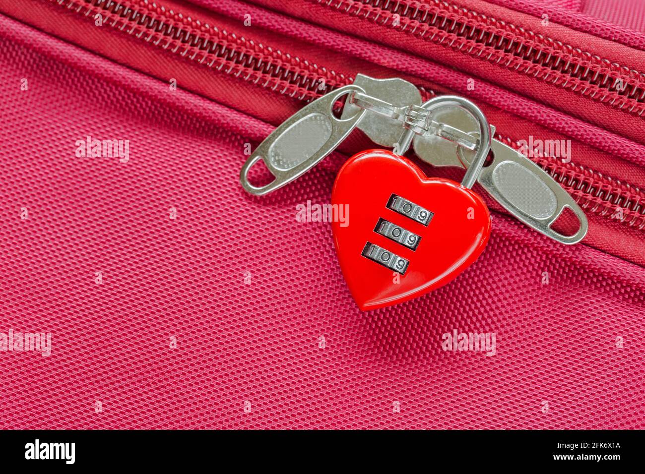 Closeup top view of red heart shaped lock with code locking fabric ...