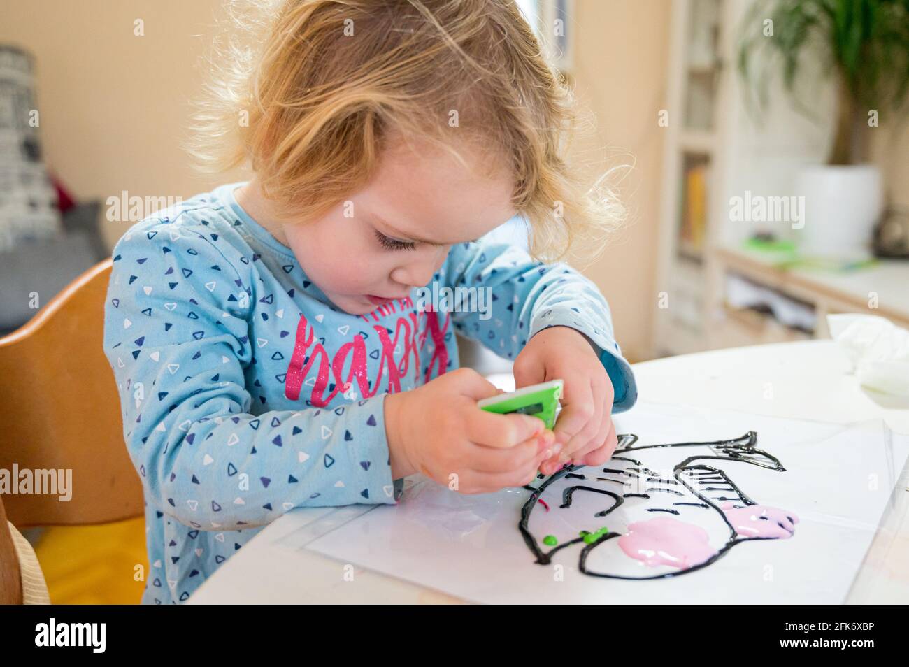 Cute girl drawing a fish using glass colors at home Stock Photo - Alamy