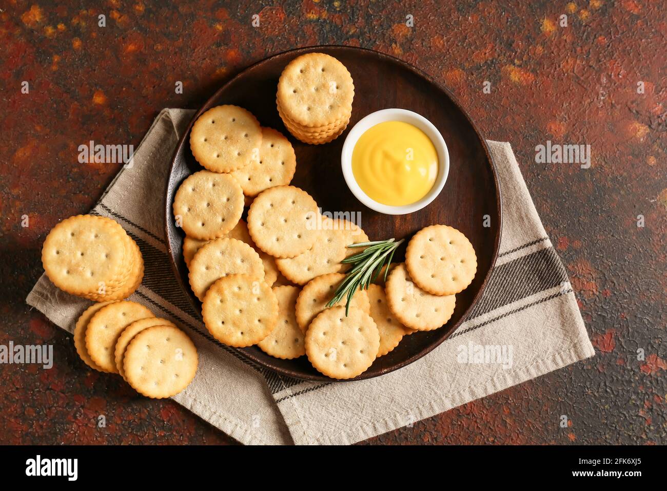 Plate with tasty crackers on grunge background Stock Photo - Alamy