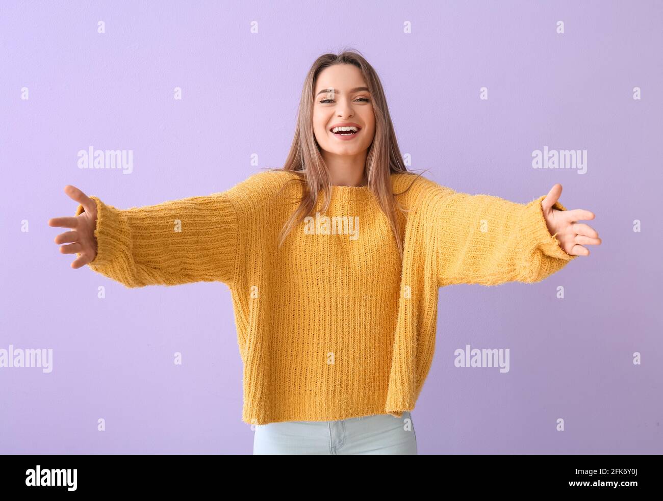 Young woman opening arms for hug on color background Stock Photo - Alamy