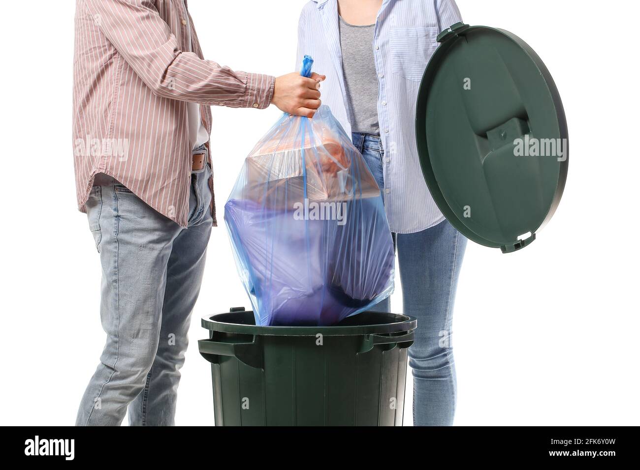 Young couple throwing garbage in trash bin on white background Stock ...