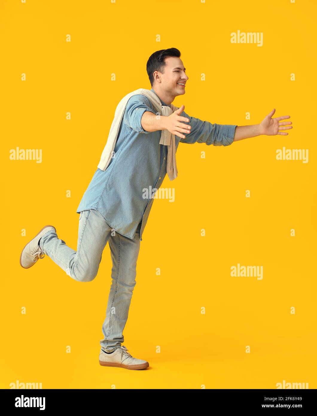 Young man opening arms for hug on color background Stock Photo - Alamy