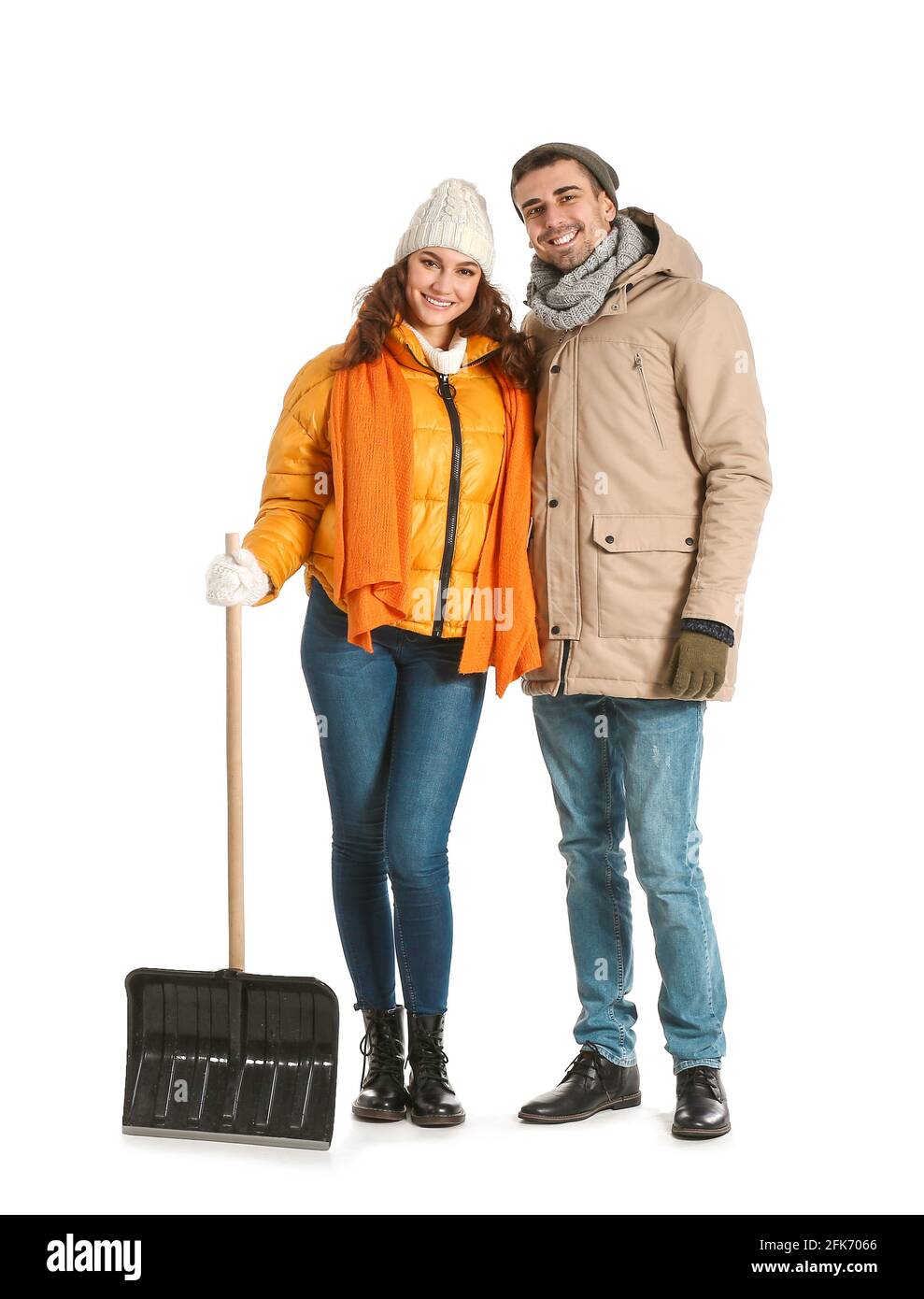 Young couple with shovel for removing snow on white background Stock ...