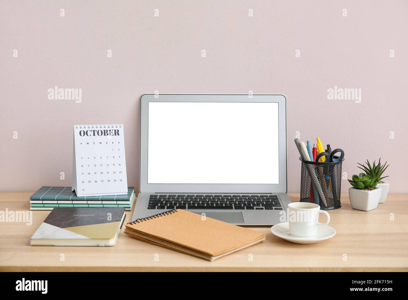 Flip paper calendar with laptop, cup of coffee and stationery on table ...