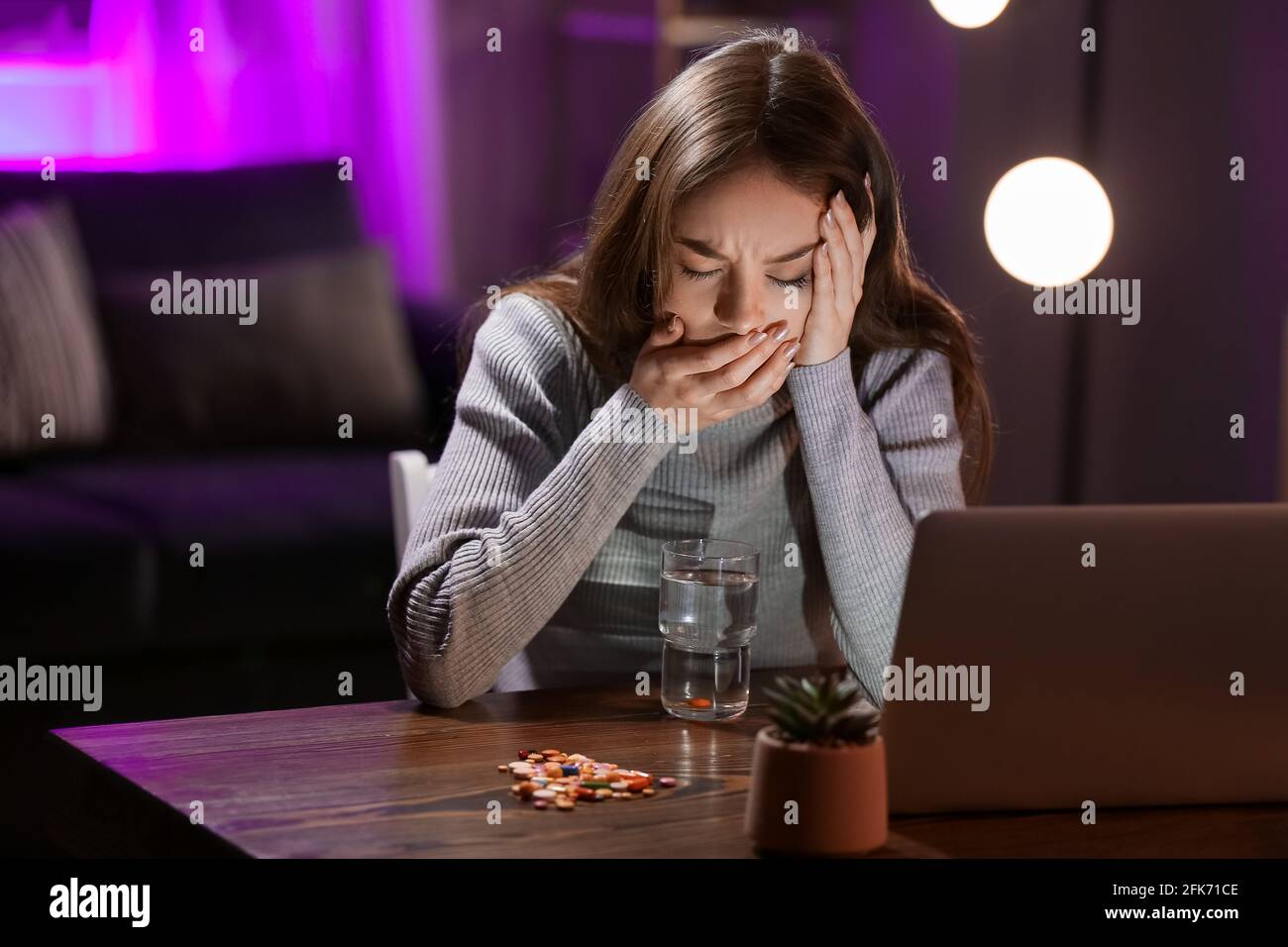 Young woman taking pills at night. Addiction concept Stock Photo - Alamy