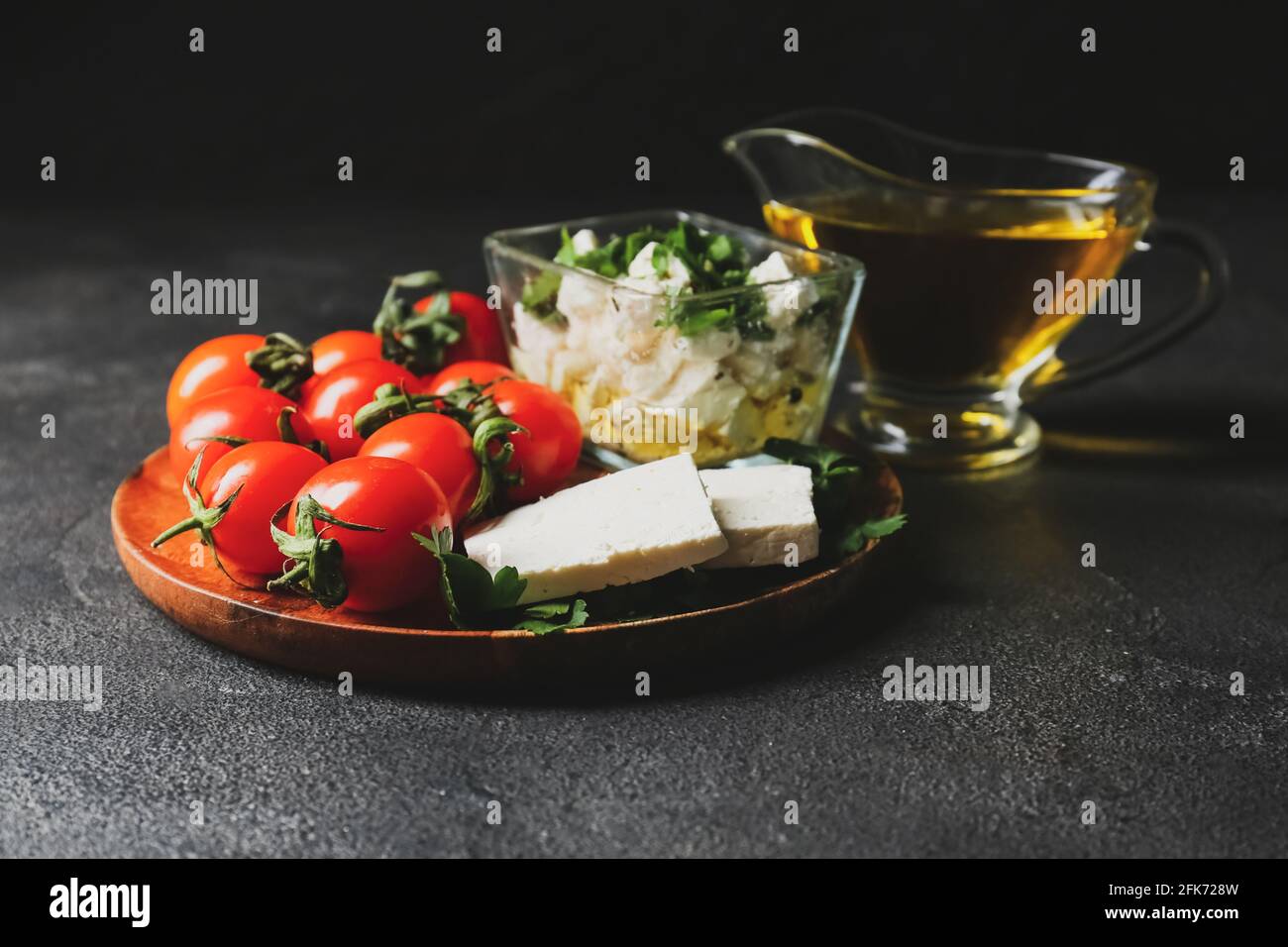 Plate with tasty feta cheese and tomatoes on dark background Stock ...