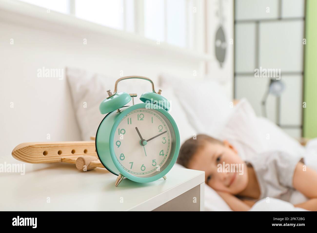 Alarm clock on table of sleepy little boy in bedroom Stock Photo - Alamy