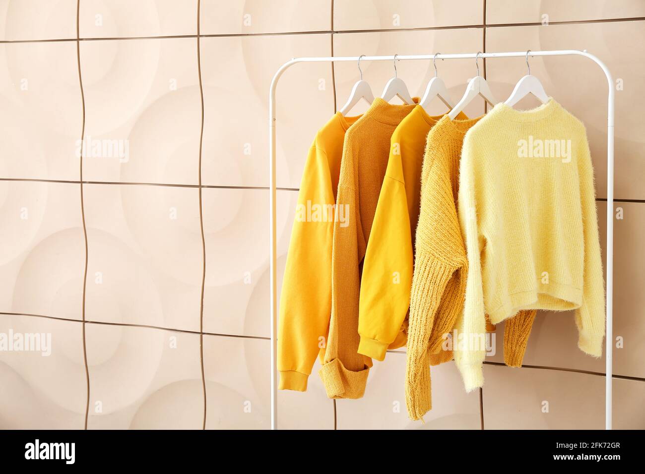 Rack with modern clothes in room Stock Photo - Alamy