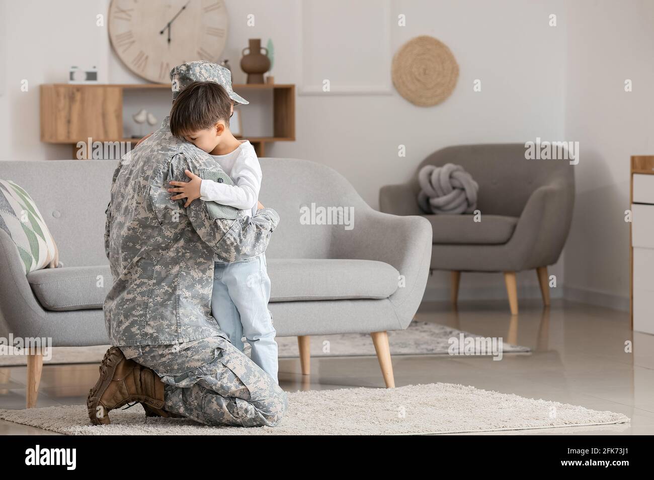 Soldier and his little son hugging at home Stock Photo - Alamy