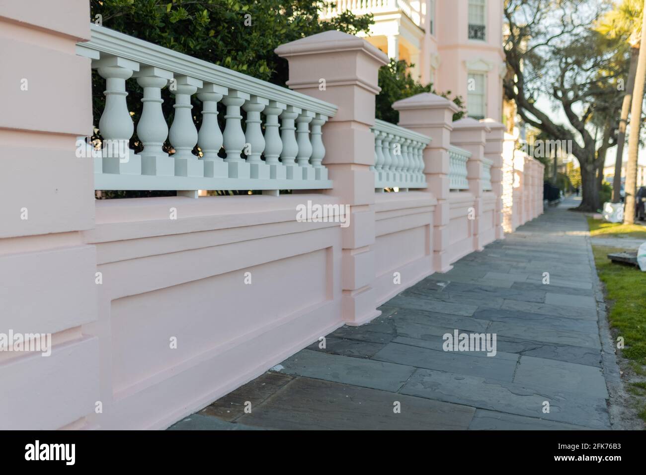 Pastel-pink wall with small white columns on sidewalk Stock Photo - Alamy