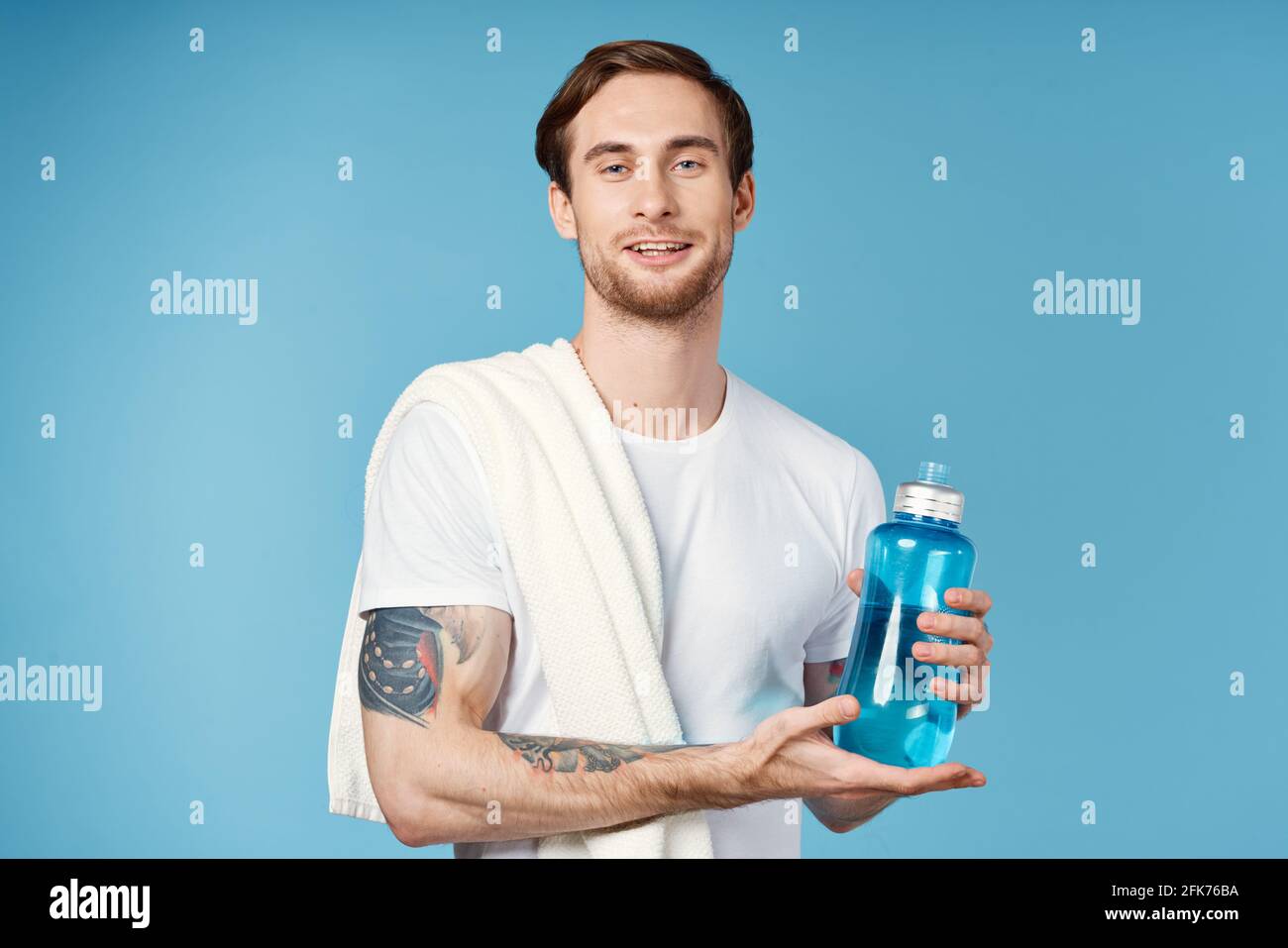 sporty man with tattoos on his arms blue workout water bottle Stock ...