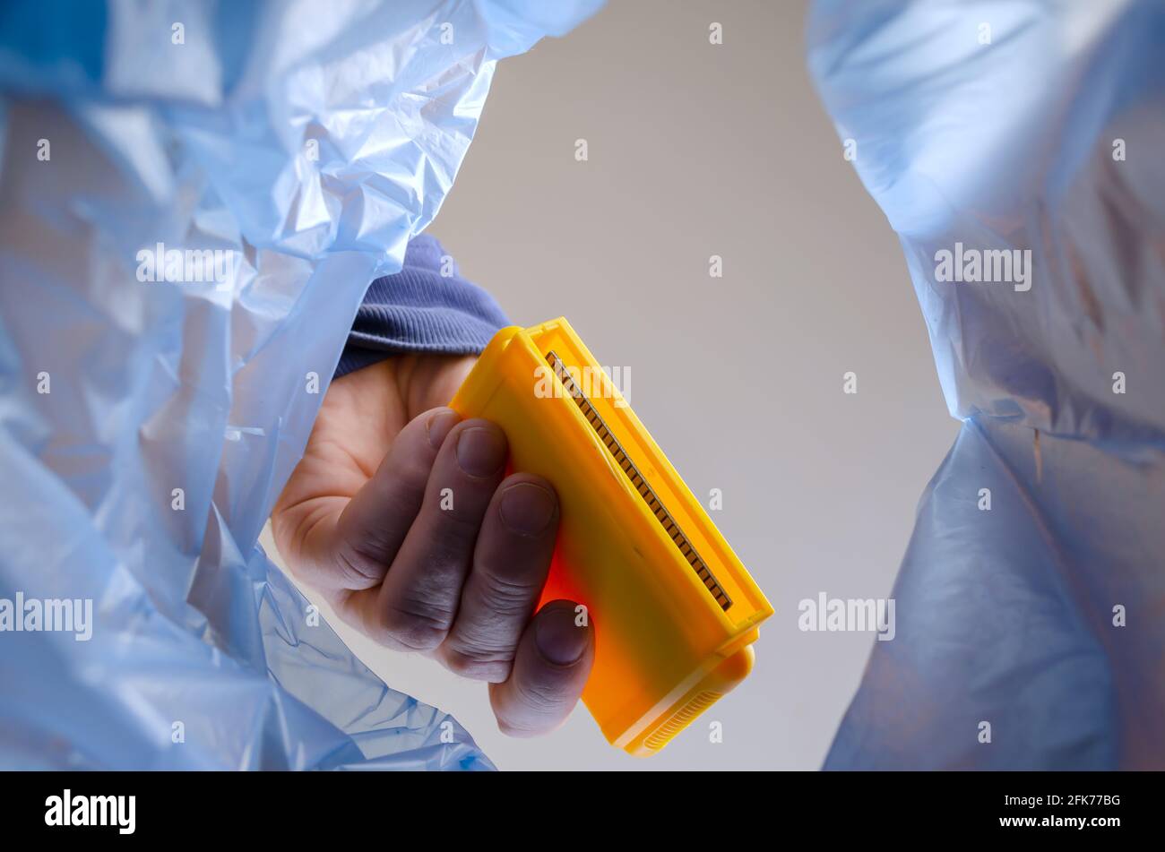 The hand throws the yellow video game cartridge into the trash. A man ...