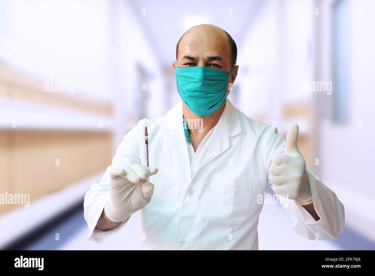 Portrait of Doctor wearing mask holding syringe Covid-19 or coronavirus ...