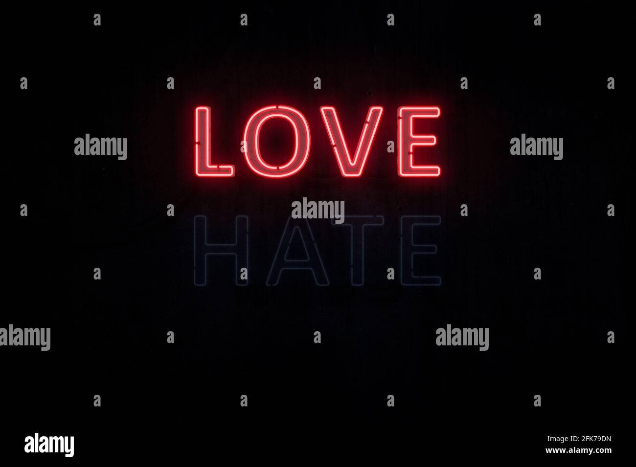 Illuminated and glowing red "LOVE" neon sign on dark, almost black ...