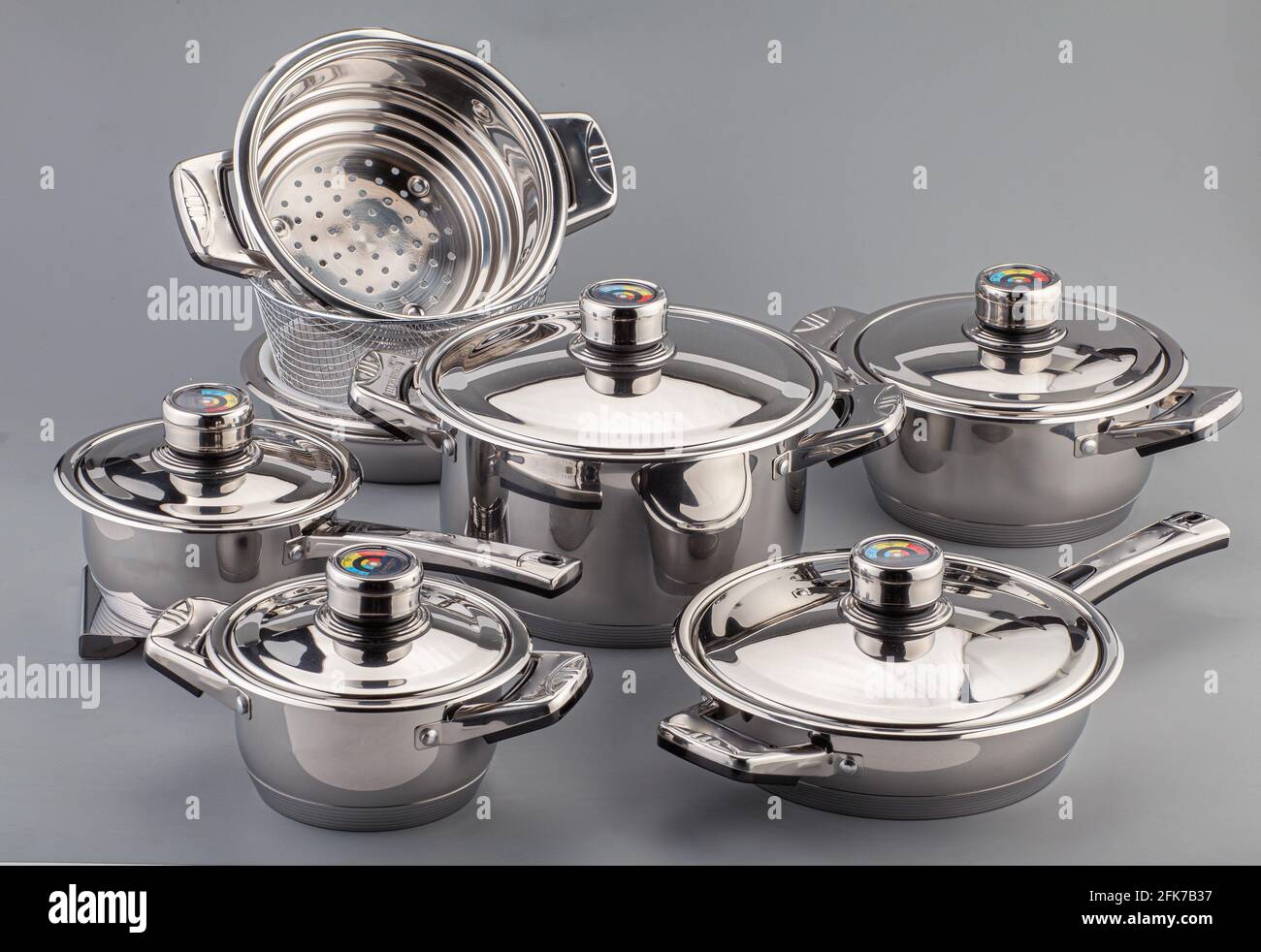 Stainless steel cookware, pots and pans on gray background. Kitchenware ...