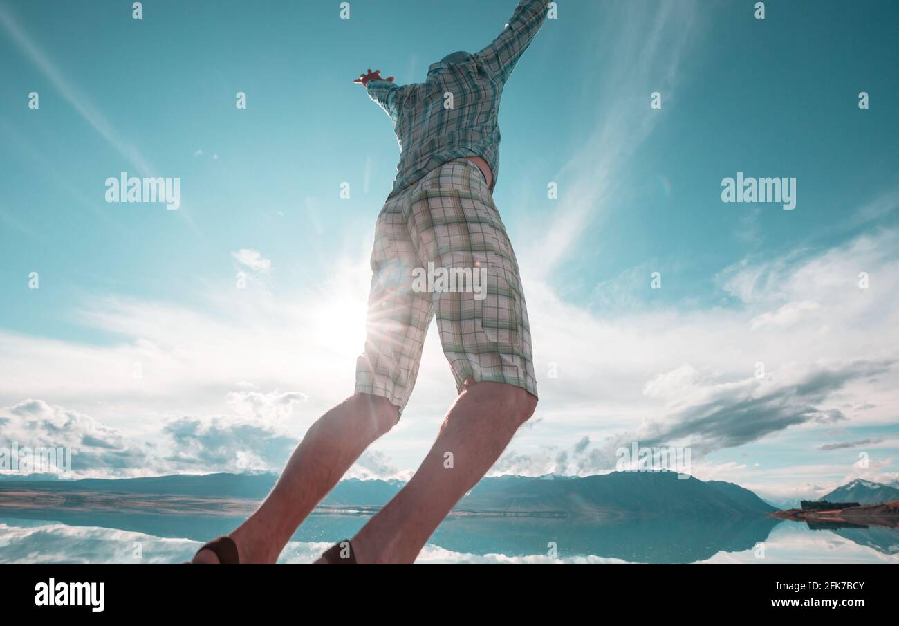Jumping man above mountains lake Stock Photo - Alamy