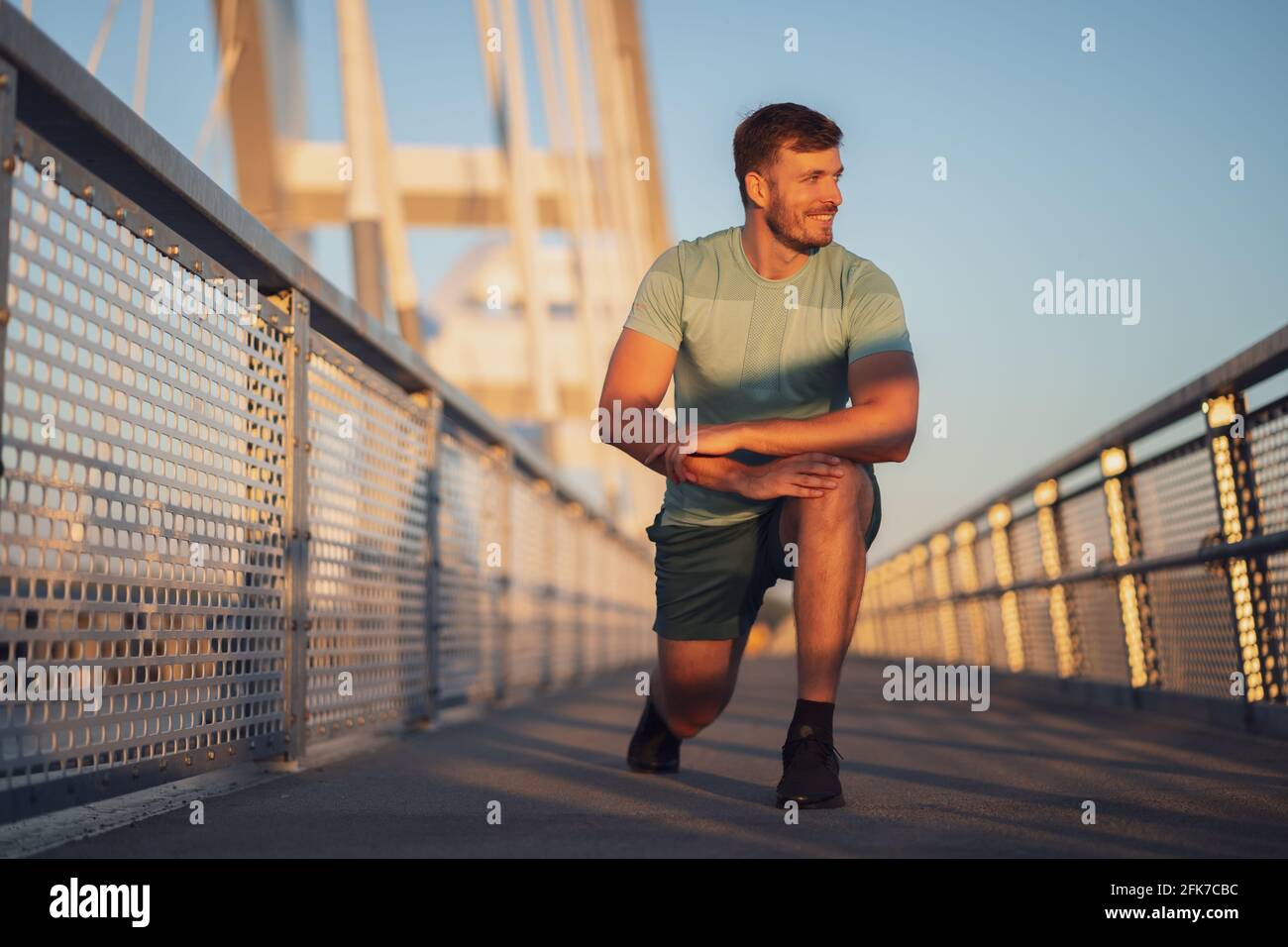 Young man stretching on bridge hi-res stock photography and images - Alamy