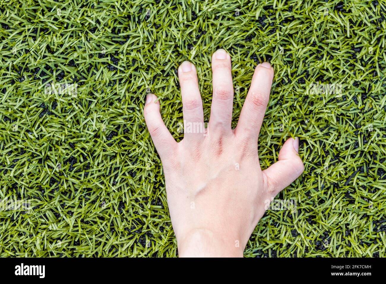 girl hand on soccer field grass background Stock Photo - Alamy