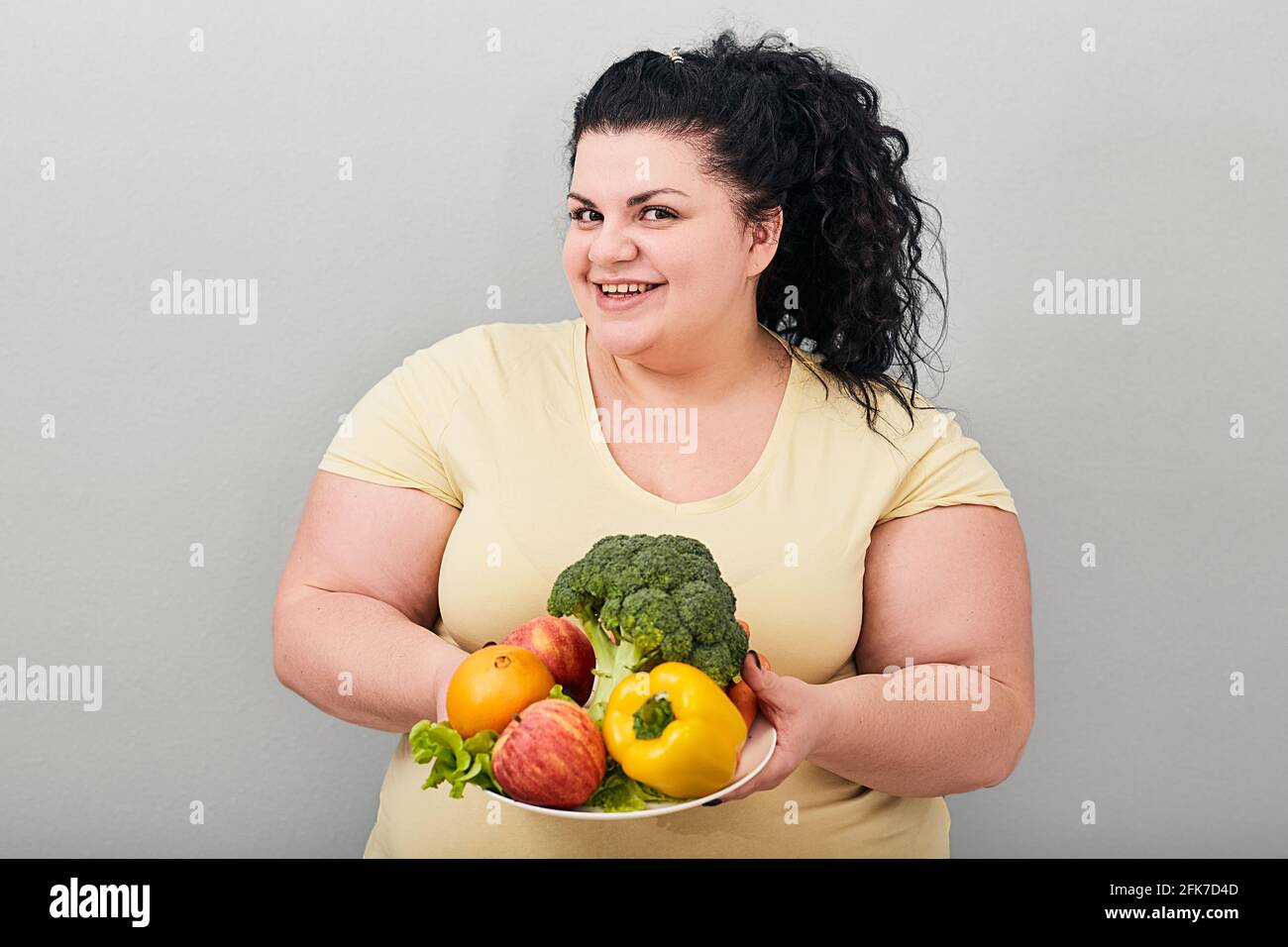 Overweight woman with fresh vegetables. Concept healthy nutrition Stock ...