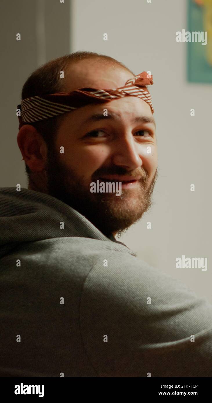 Pro man gamer turning head looking at camera smiling playing FPS ...