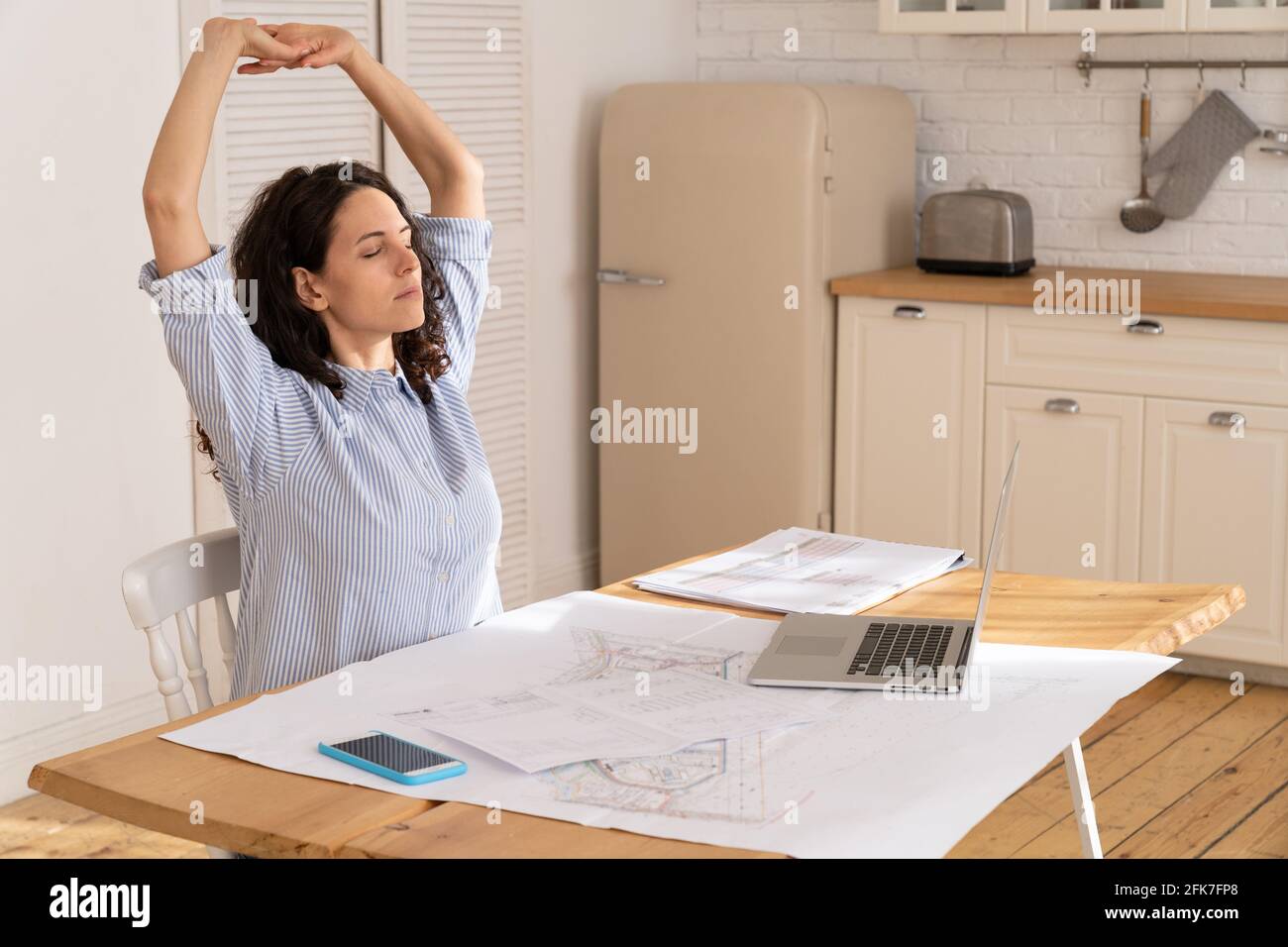 Businesswoman stretch to relieve tension from sedentary work in remote ...