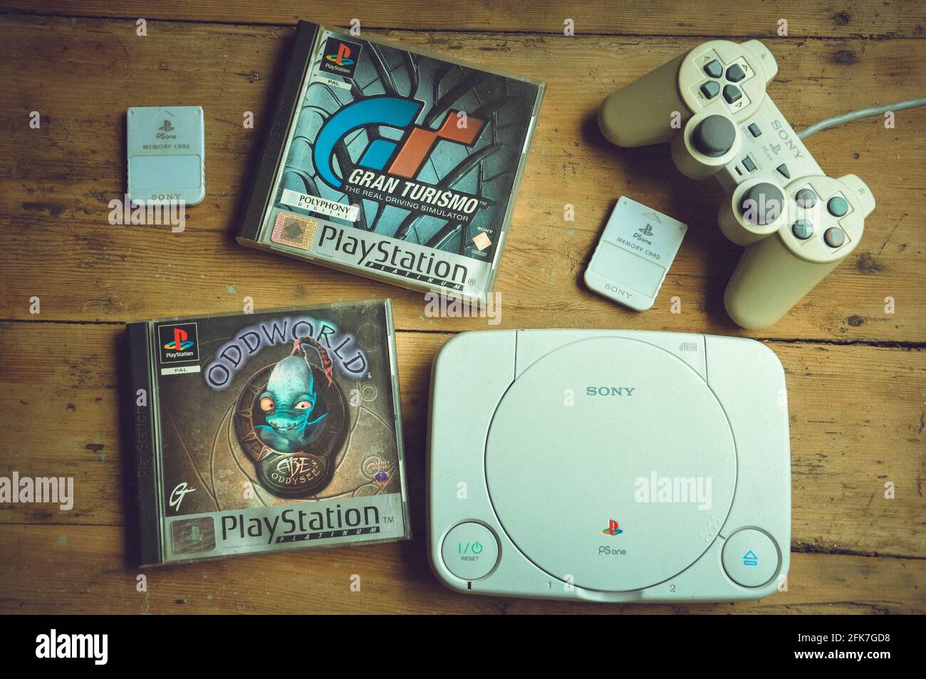 Sony Playstation One Slim with memory cards and controller on wooden ...
