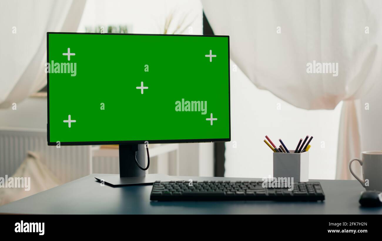 Powerful computer with chroma key green screen mock up stands on desk ...