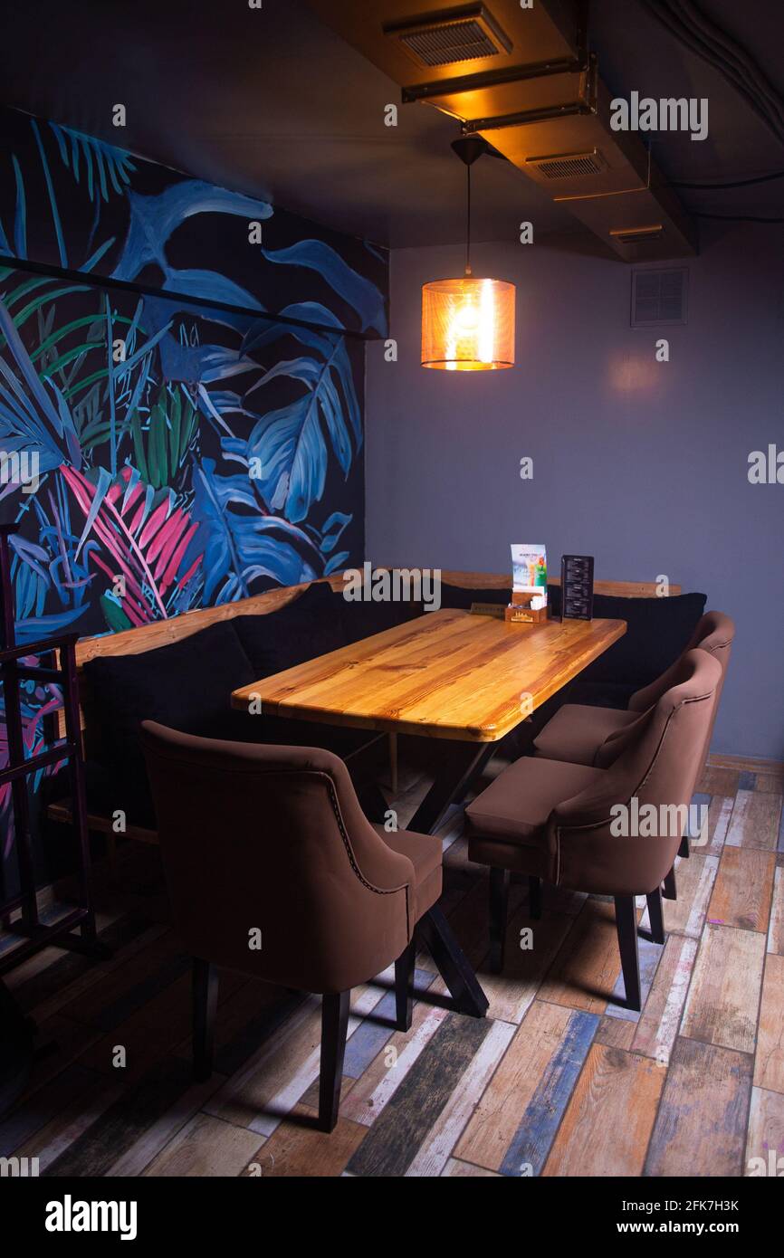 table in a cafe with neon drawings on the walls Stock Photo - Alamy
