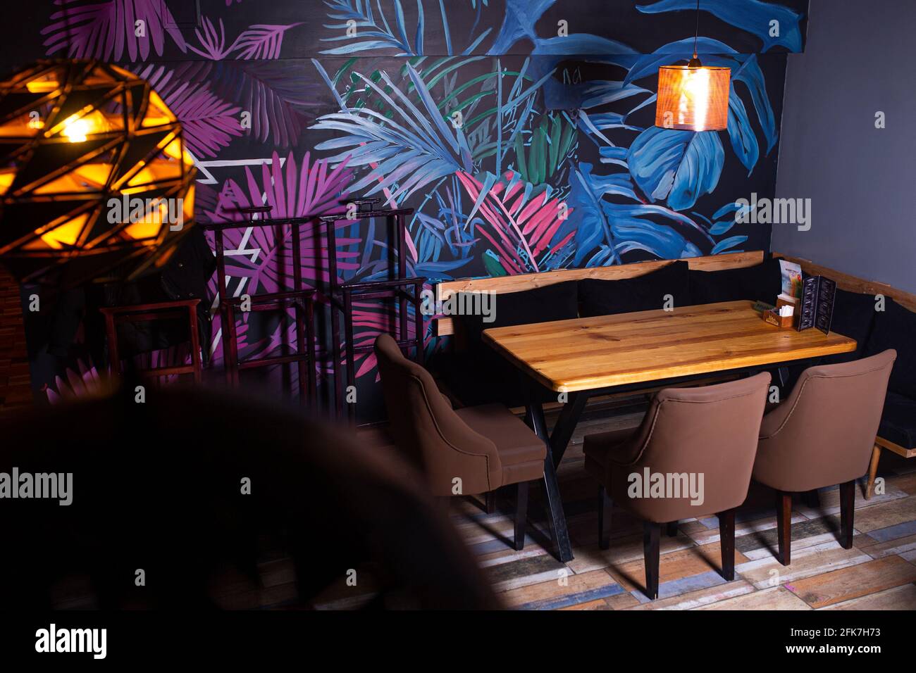 table in a cafe with neon drawings on the walls Stock Photo - Alamy