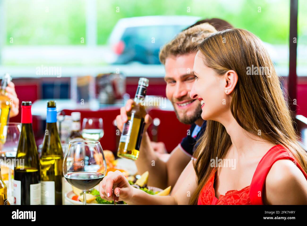 Friends or couples eating fast food and drinking beer in a American ...