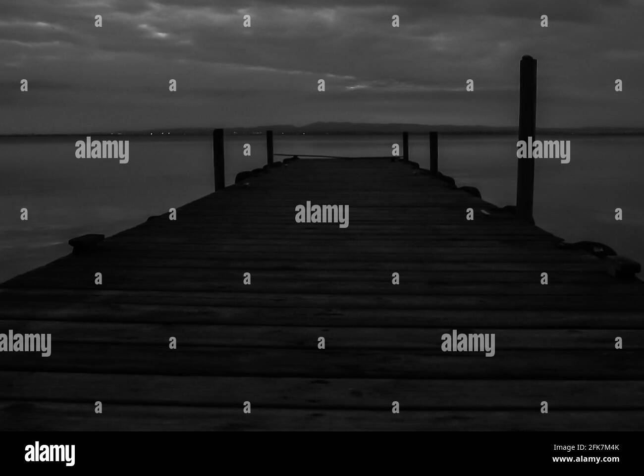 Dramatic and moody shot of an old wooden dock under a gloomy sky Stock ...