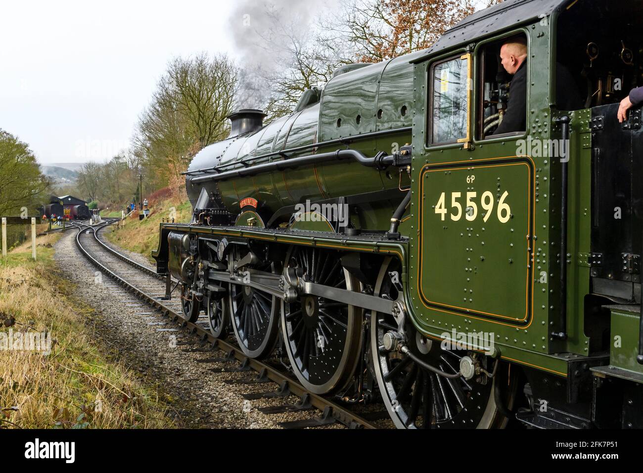Historic steam train loco on tracks puffing smoke, travelling on ...
