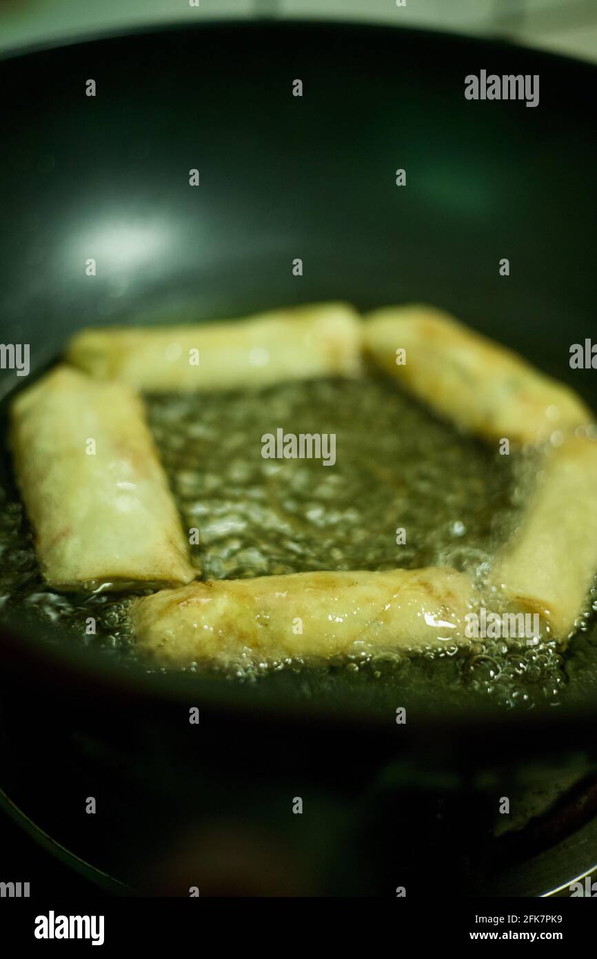 Vertical shot of spring rolls frying in a pan Stock Photo - Alamy