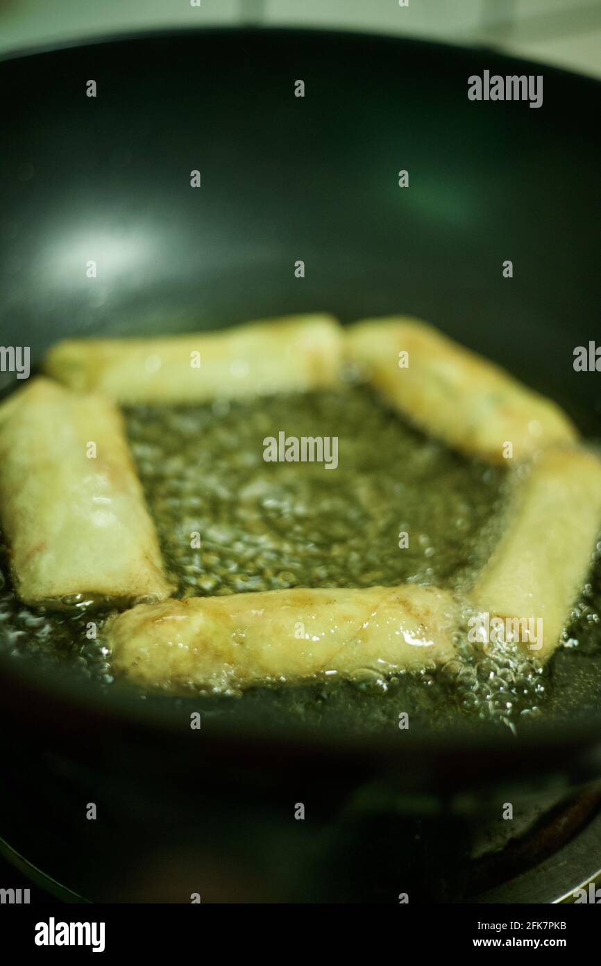 Vertical shot of spring rolls frying in a pan Stock Photo - Alamy