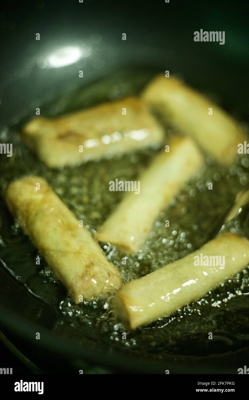 Vertical shot of spring rolls frying in a pan Stock Photo - Alamy