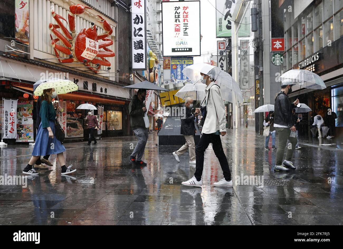People wearing face masks walk in Osaka's Minami area on April 29, 2021 ...