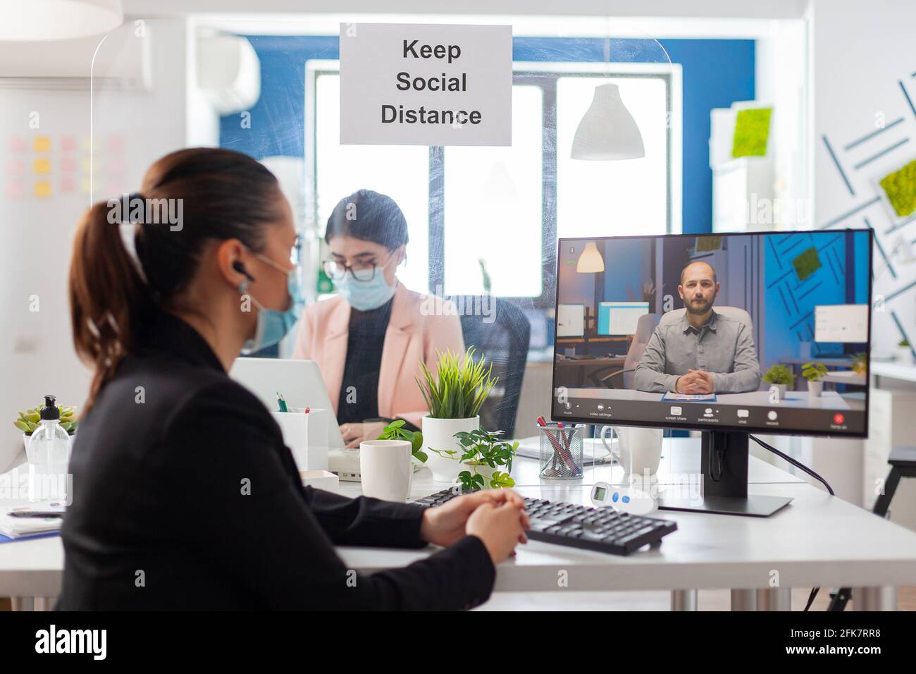 Coworkers discussing project during remote call from new workplace in ...