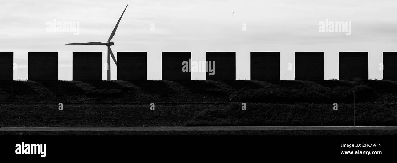 Concrete road barrier with a windmill on a clear sky background in ...