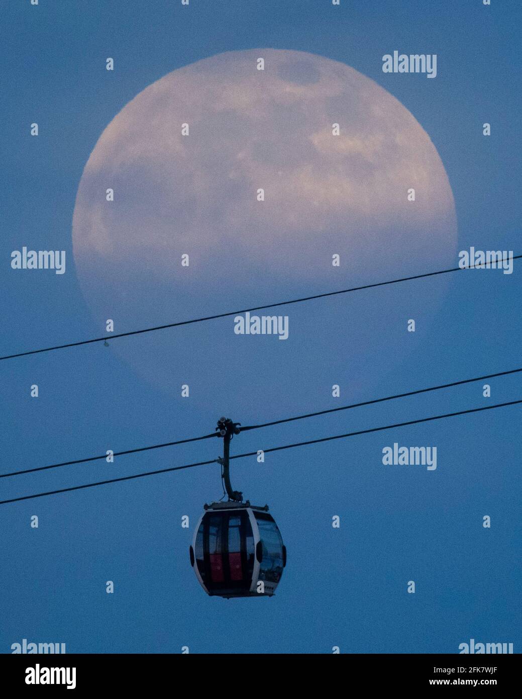A super pink moon, also known as a pink supermoon is seen behind the ...