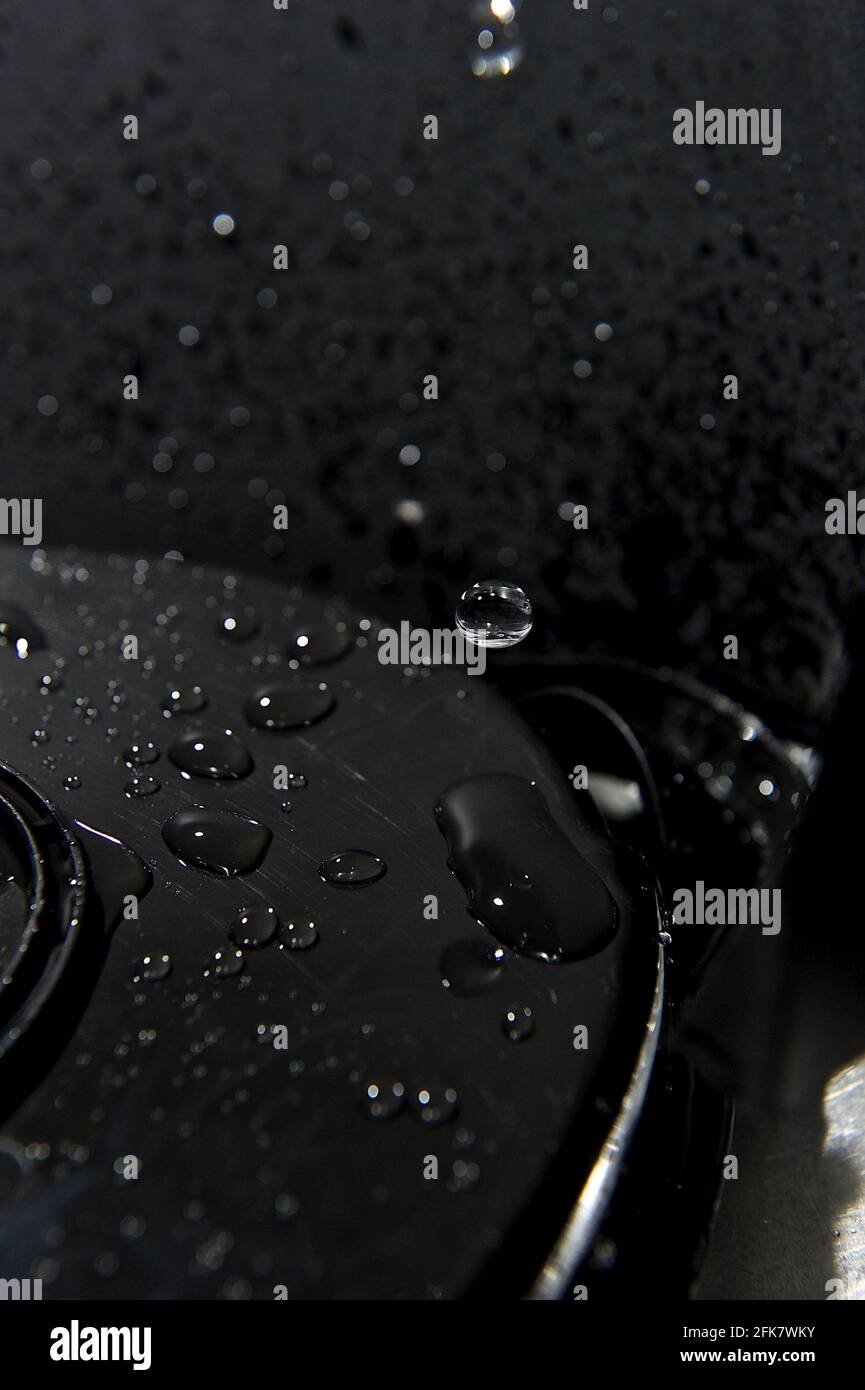 Vertical greyscale shot of drops of water dripping a surface Stock ...