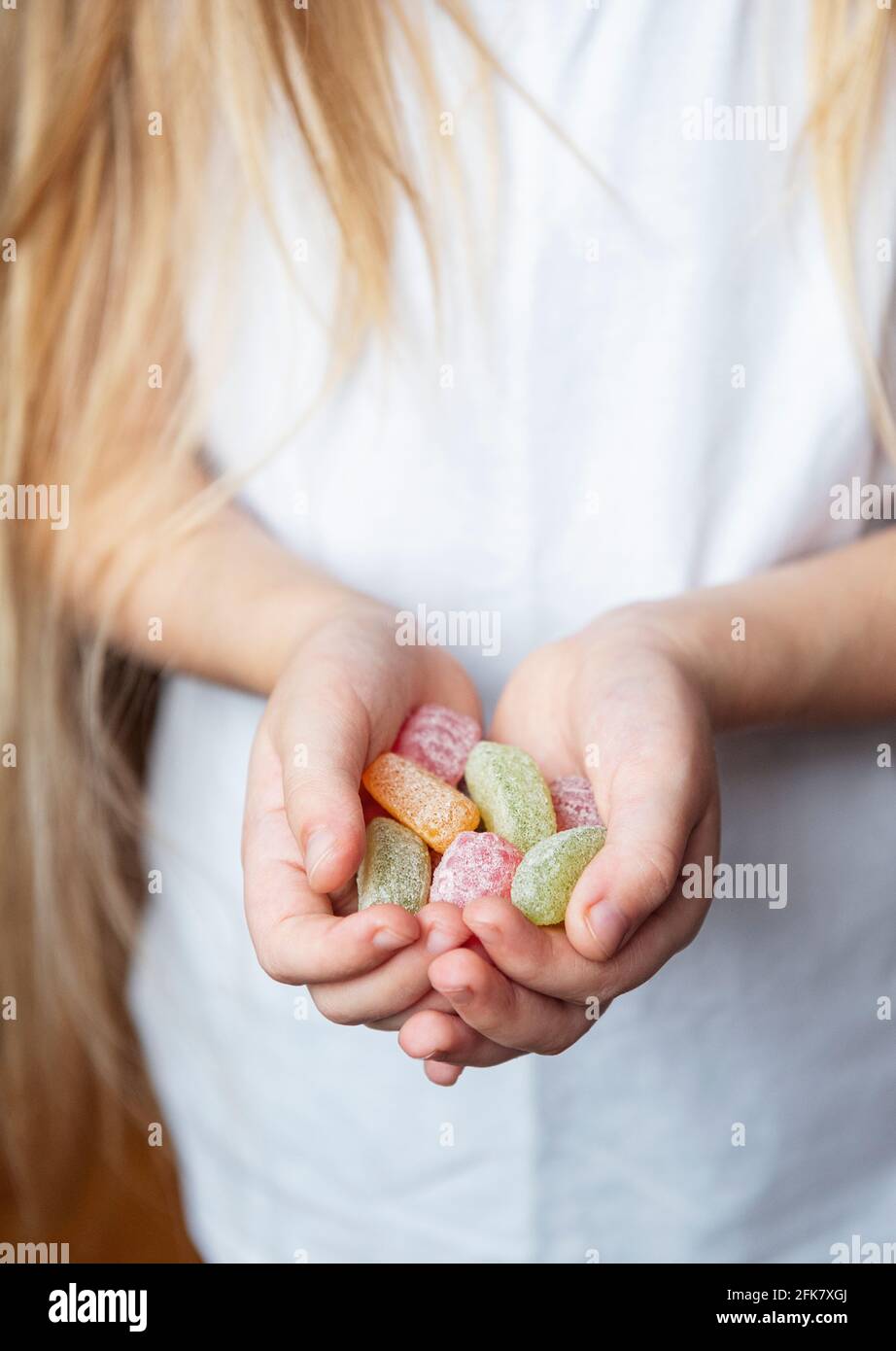 Little girl holding sweet candies in her hands Stock Photo - Alamy
