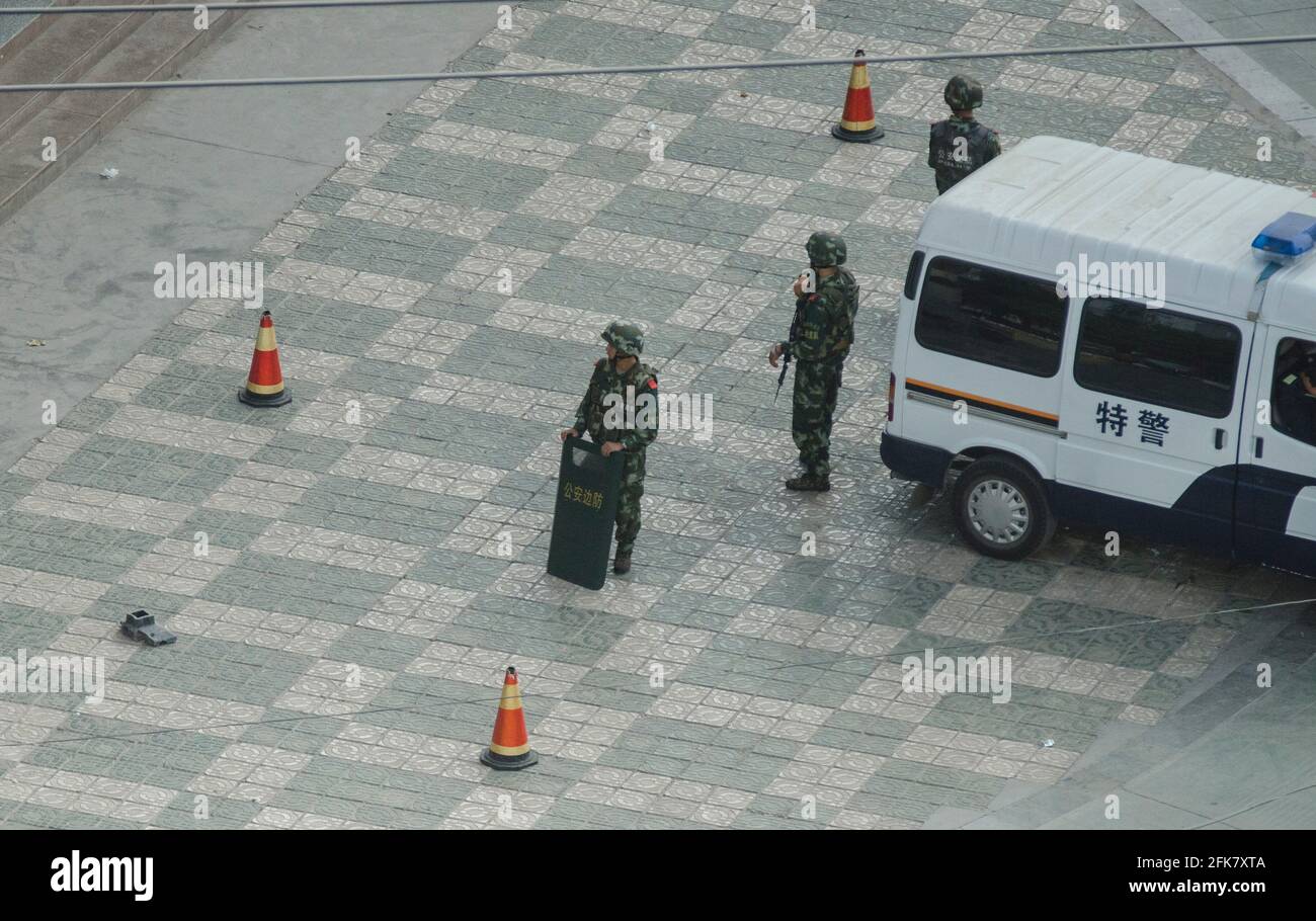 Security police with shields, batons and firearms stand by a police van ...