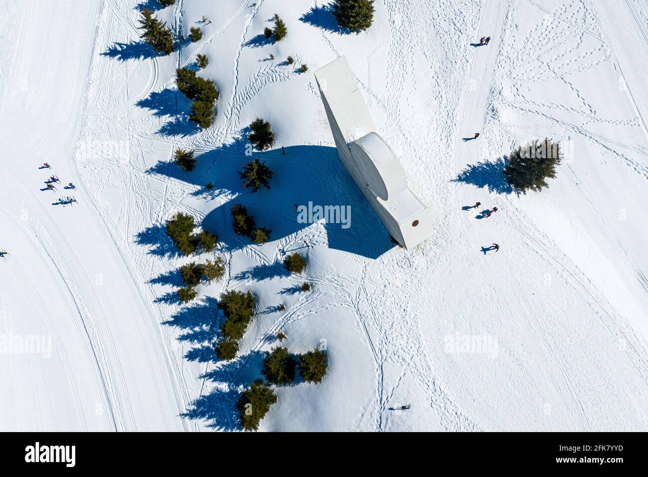 Top Down shot of a structure and some people walking by it in groups ...